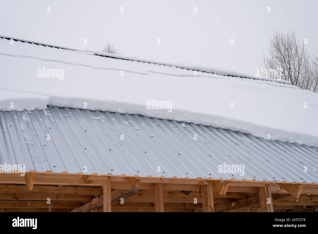 snow sliding down from roof. building construction house with metal ...