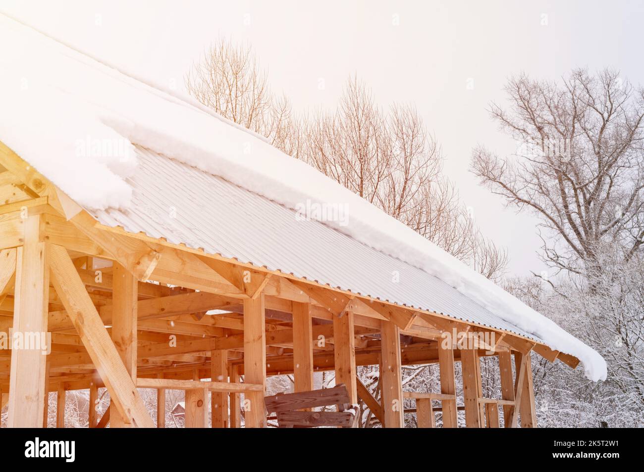 snow sliding down from roof. building construction house with metal ...
