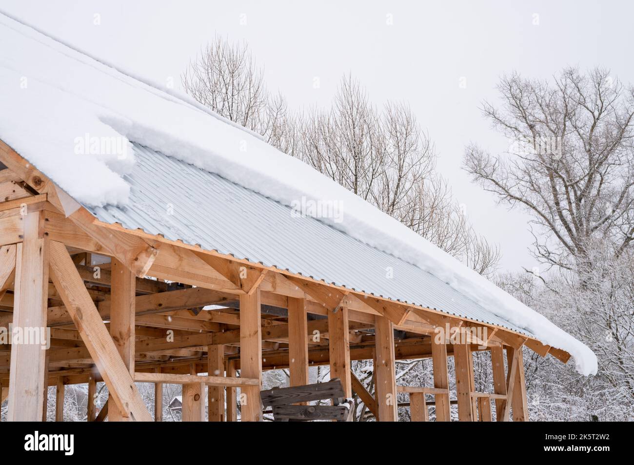 snow sliding down from roof. building construction house with metal ...
