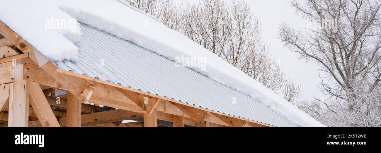 snow sliding down from roof. building construction house with metal ...
