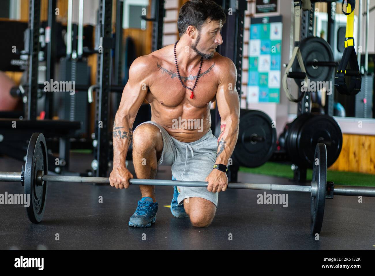 Man resting in a gym while exercising with weights Stock Photo - Alamy
