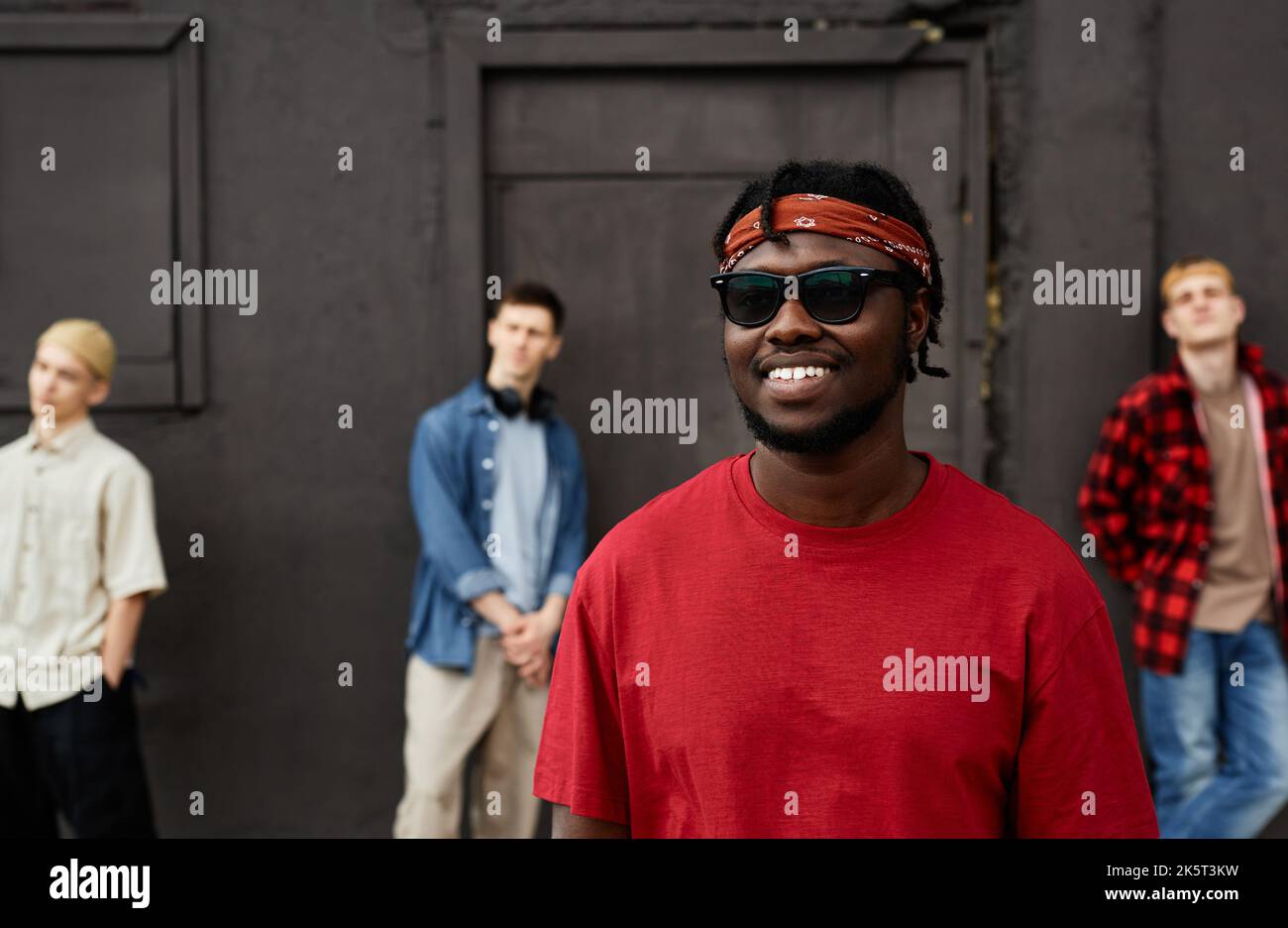 Diverse group of boys wearing street style clothes standing against ...