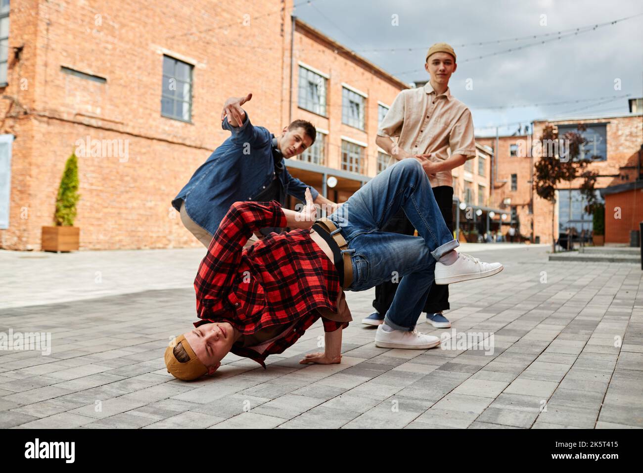 Full length shot of all male breakdance team posing outdoors in city ...