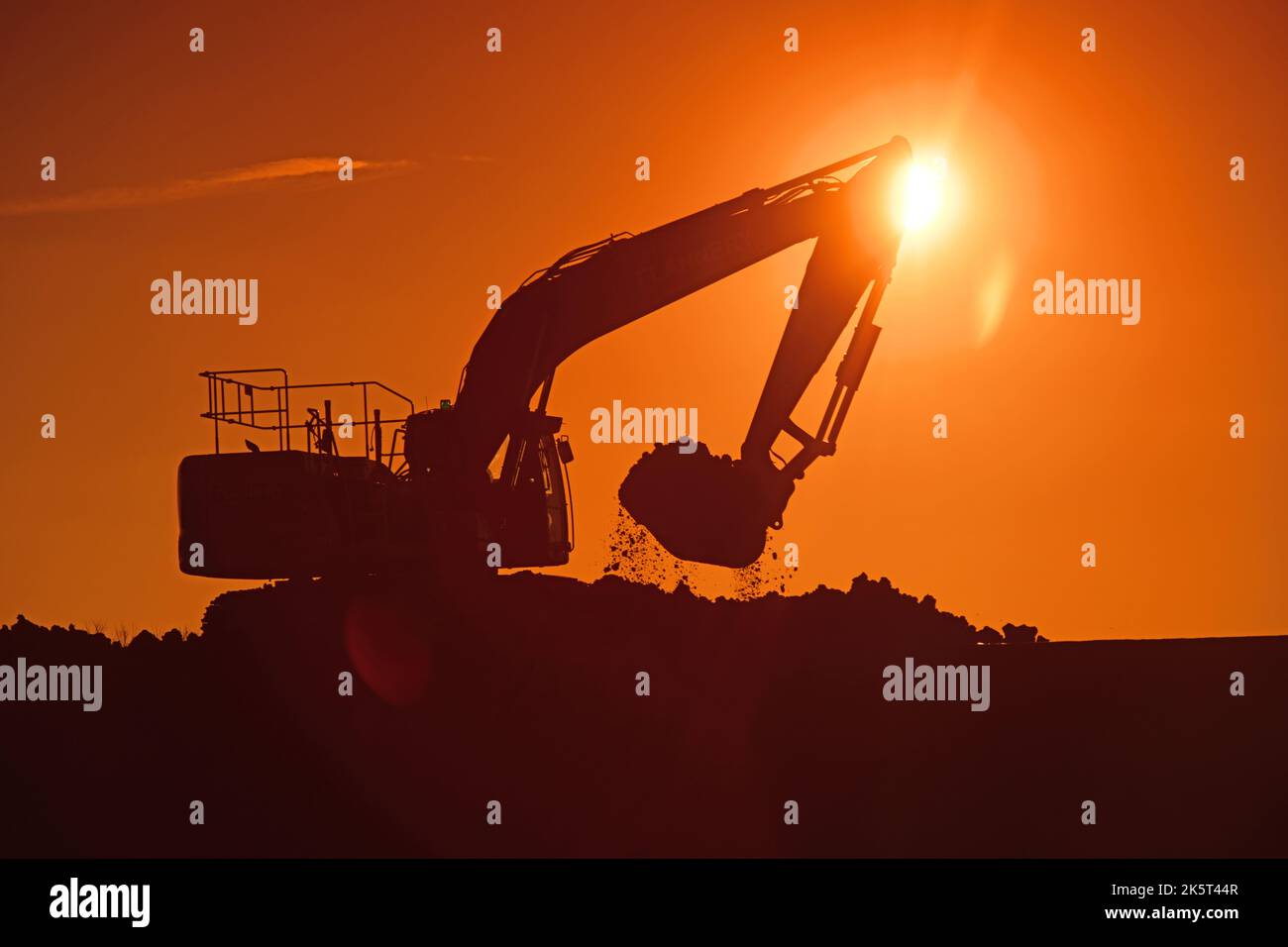 caterpillar digger working on site at sunset united kingdom Stock Photo ...