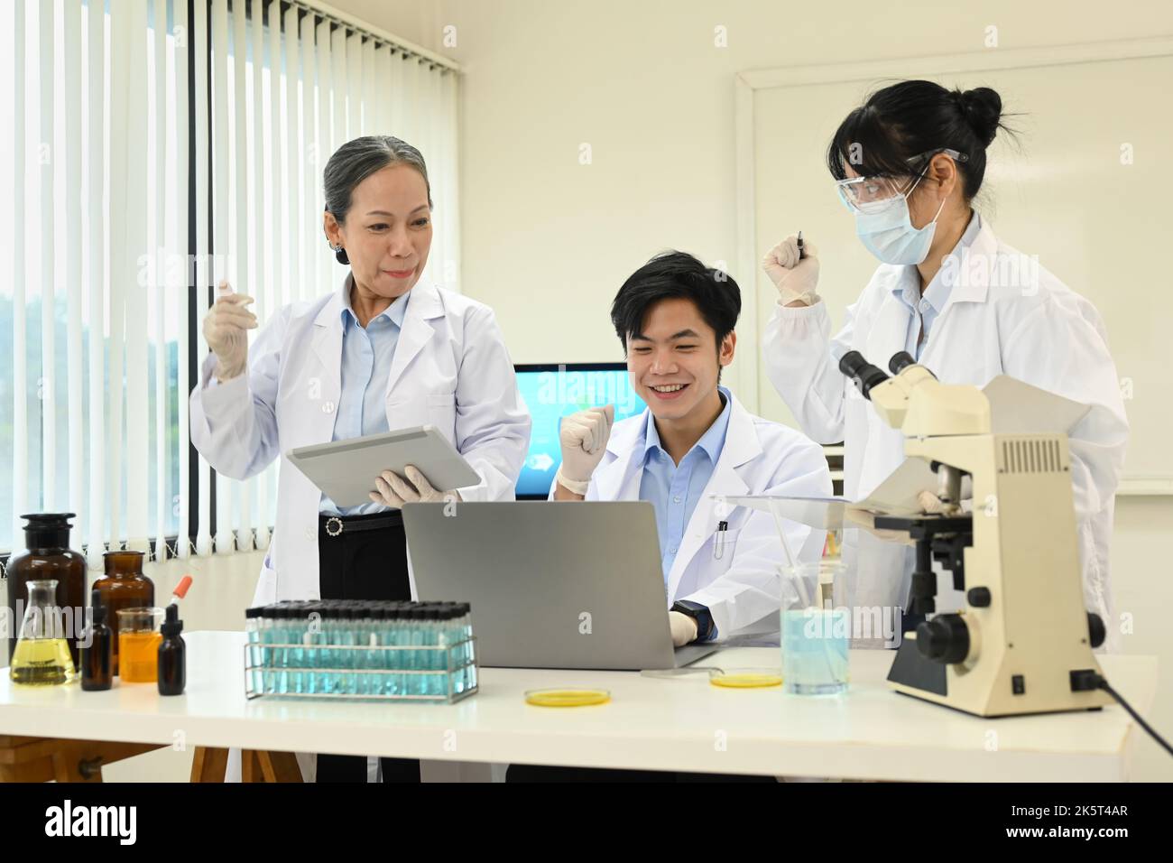 Happy researchers celebrating success results of the experiment, makes ...