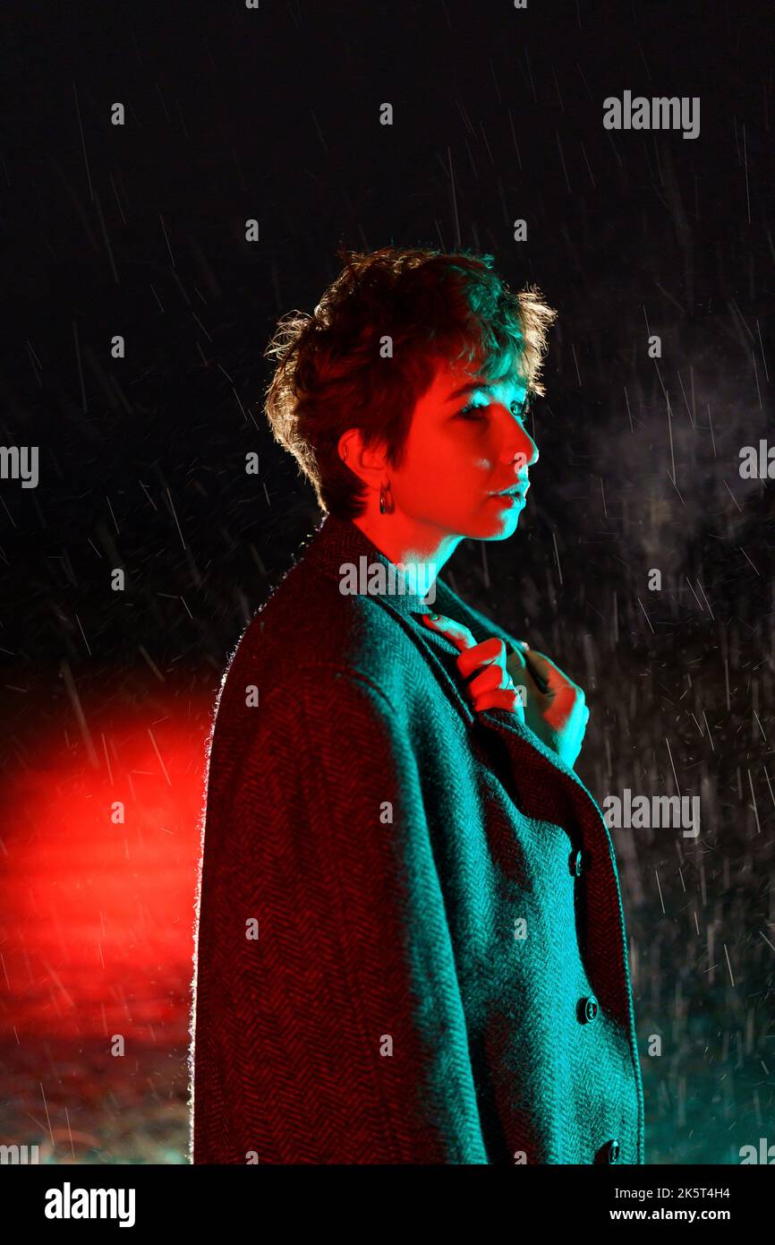 Frightened woman is freezing standing on street in snowy weather ...