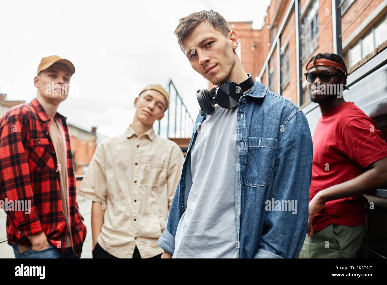 Diverse group of young men wearing streetstyle and looking at camera ...