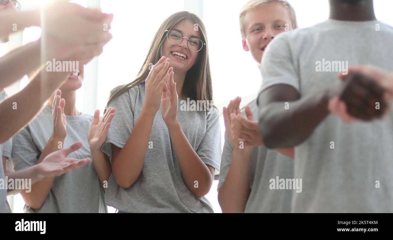 Contact group of young people applauding their coach Stock Photo - Alamy