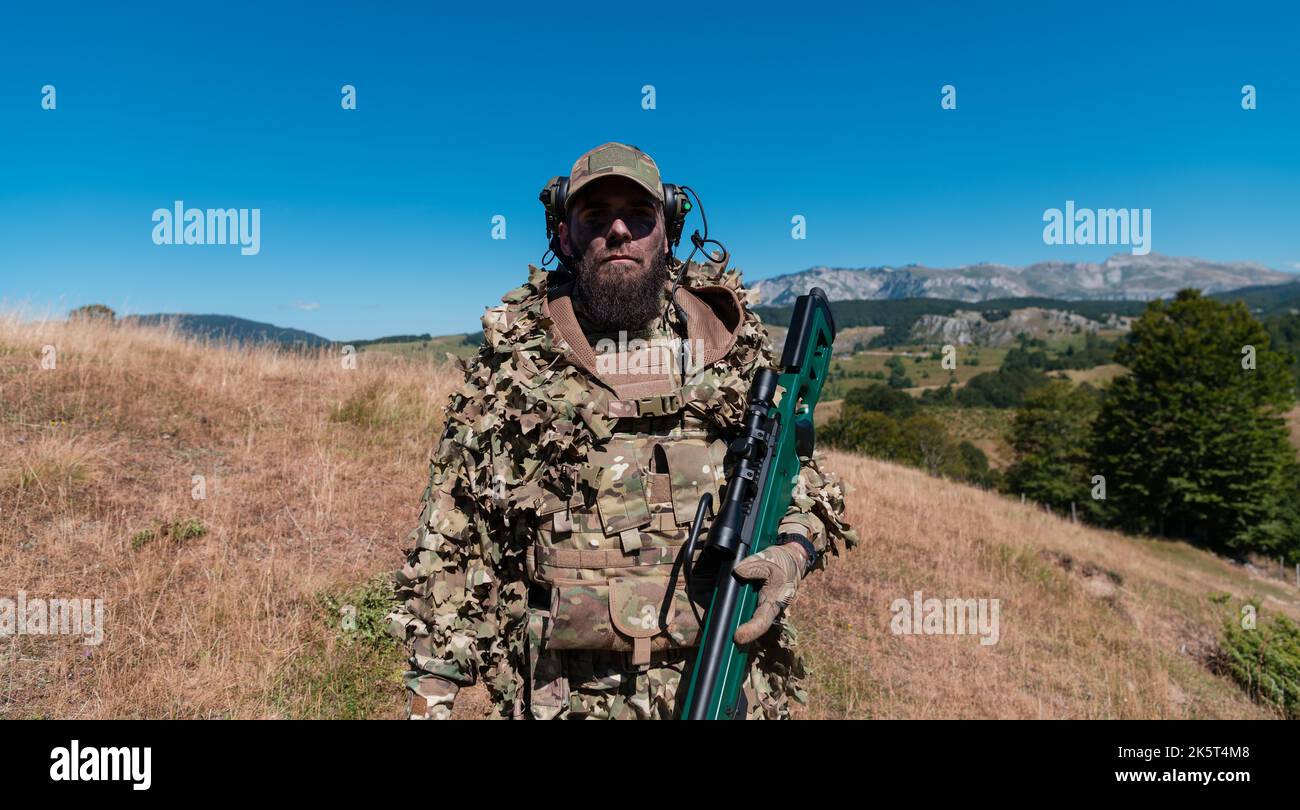 army soldier holding a sniper rifle with scope and walking in the ...