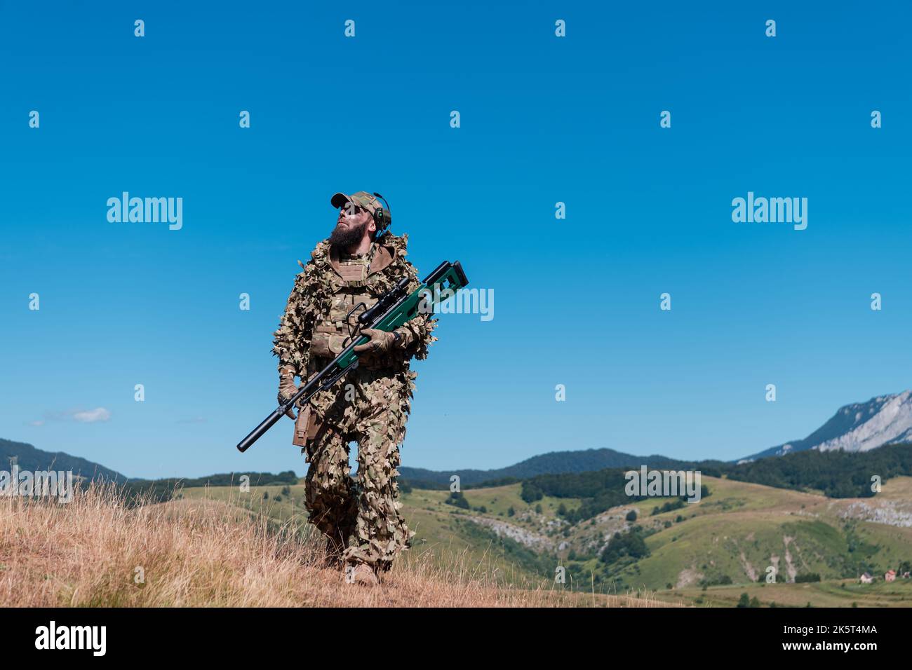 army soldier holding a sniper rifle with scope and walking in the ...