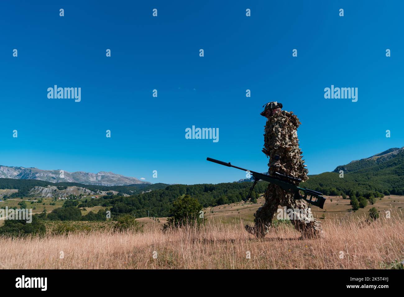 army soldier holding a sniper rifle with scope and walking in the ...
