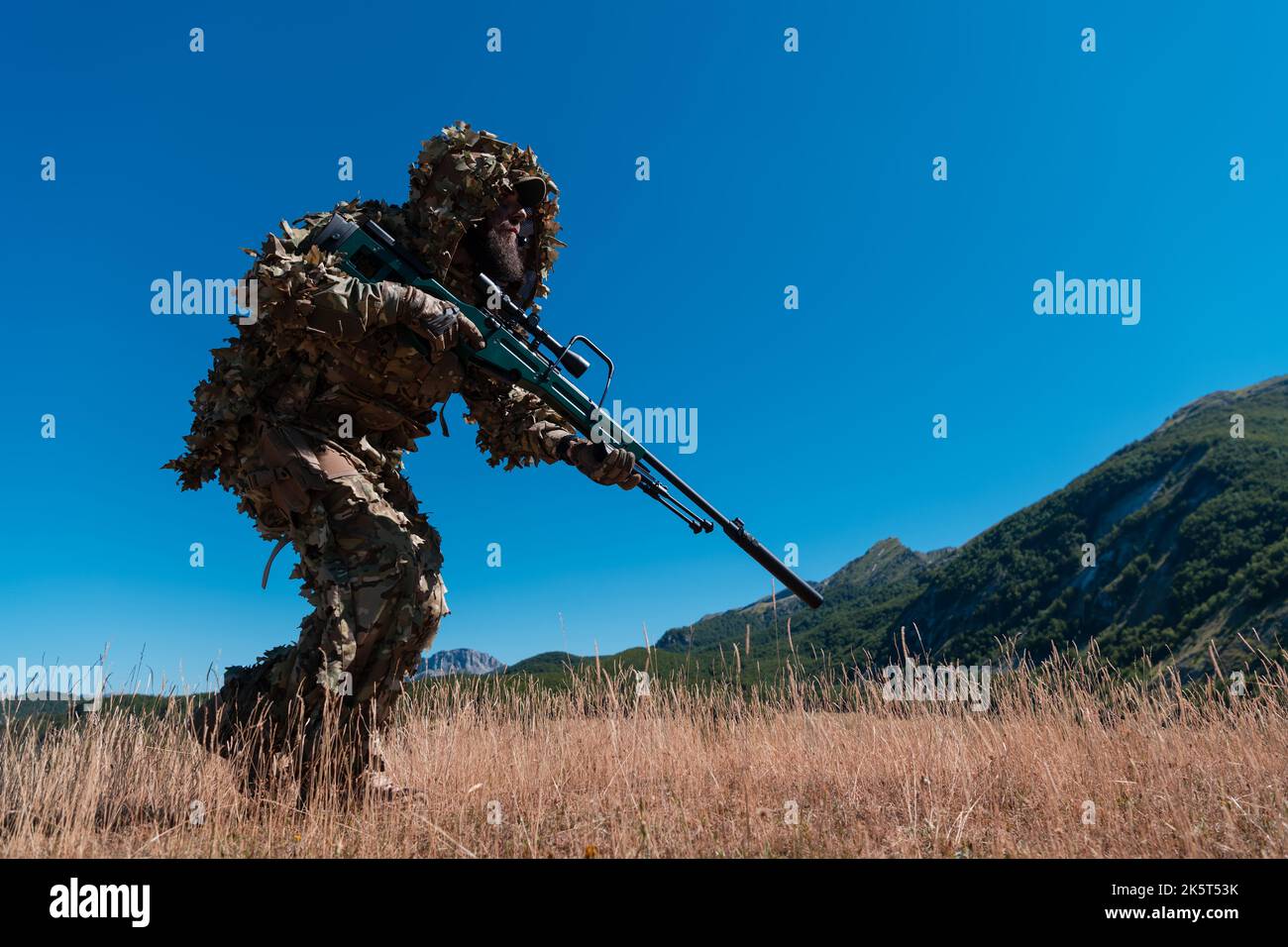 army soldier holding a sniper rifle with scope and walking in the ...