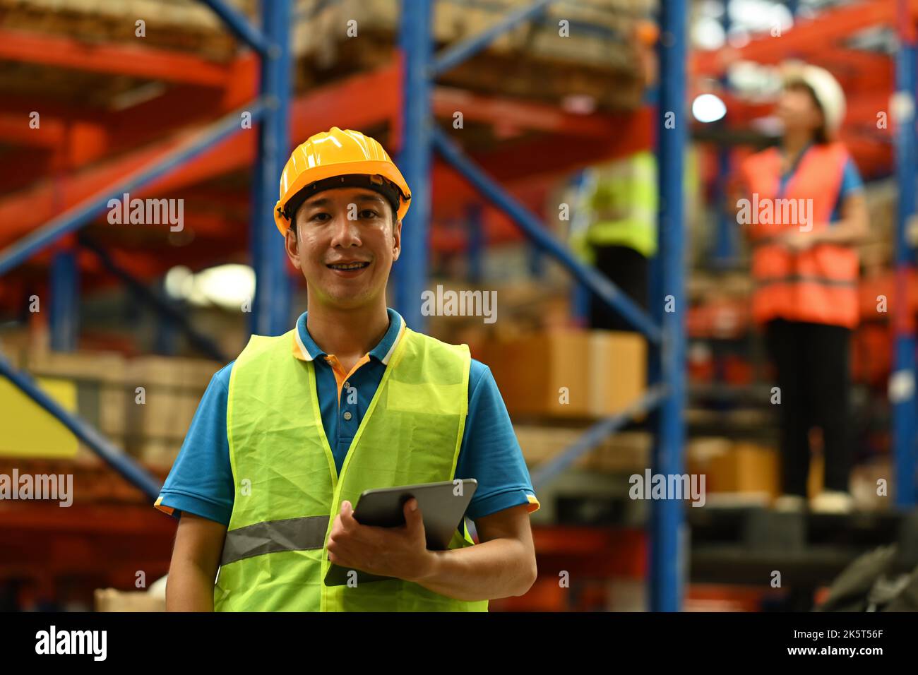 Portrait of male warehouse worker wearing safety hardhat and vest ...