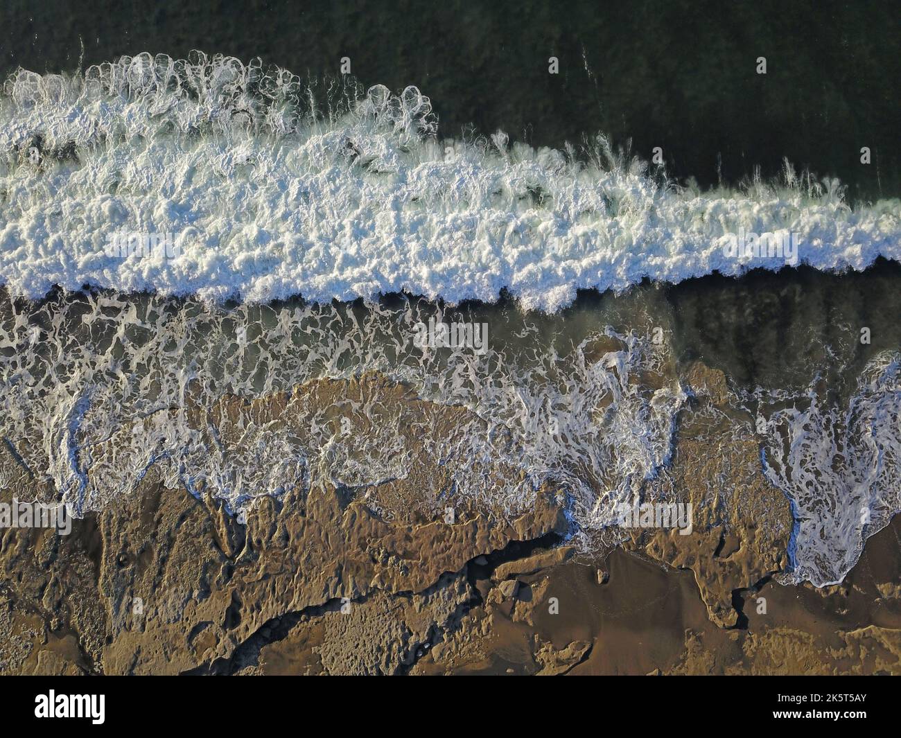 Aerial photograph of a rocky coastline with arriving and breaking ocean ...