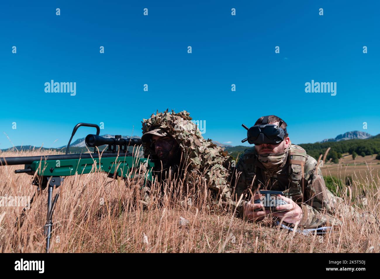 Sniper soldier assisted by an assistant to observe the area to be ...