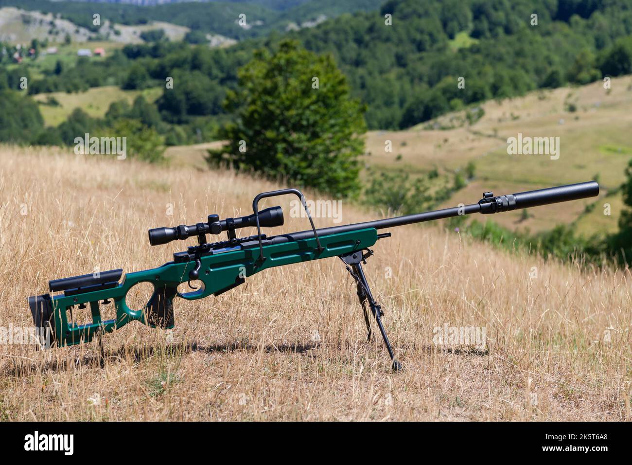 A green military sniper rifle with a scope for long distance tactical ...