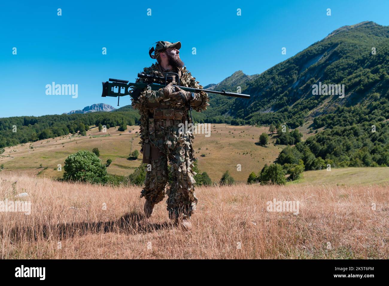 army soldier holding a sniper rifle with scope and walking in the ...