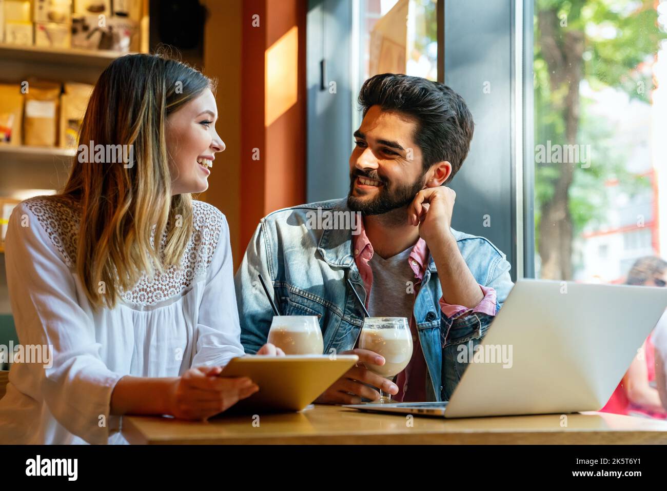 Happy couple in love using digital devises for work, study or social ...