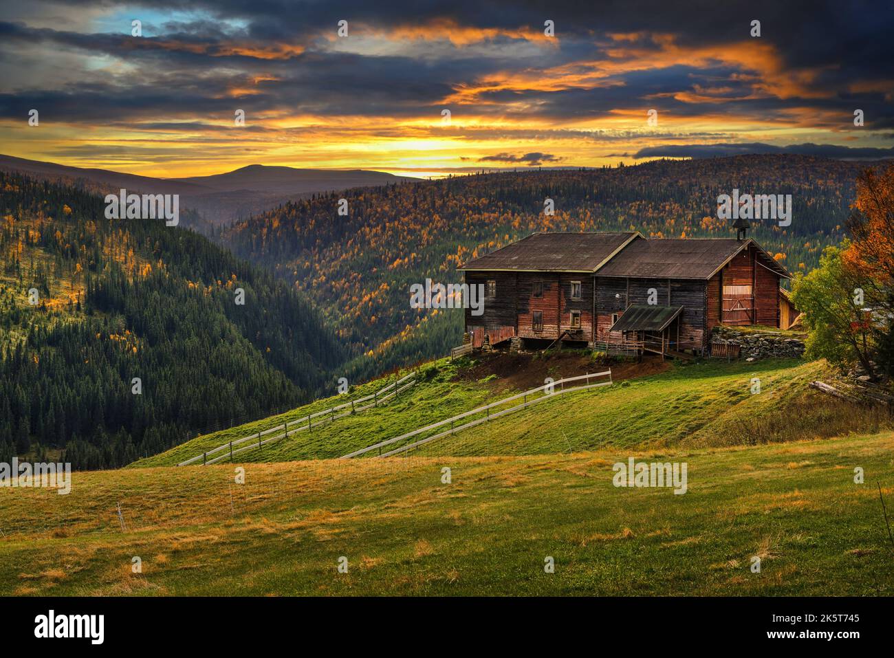 Sunset over a farmhouse barn in autumn near Rondane National Park ...