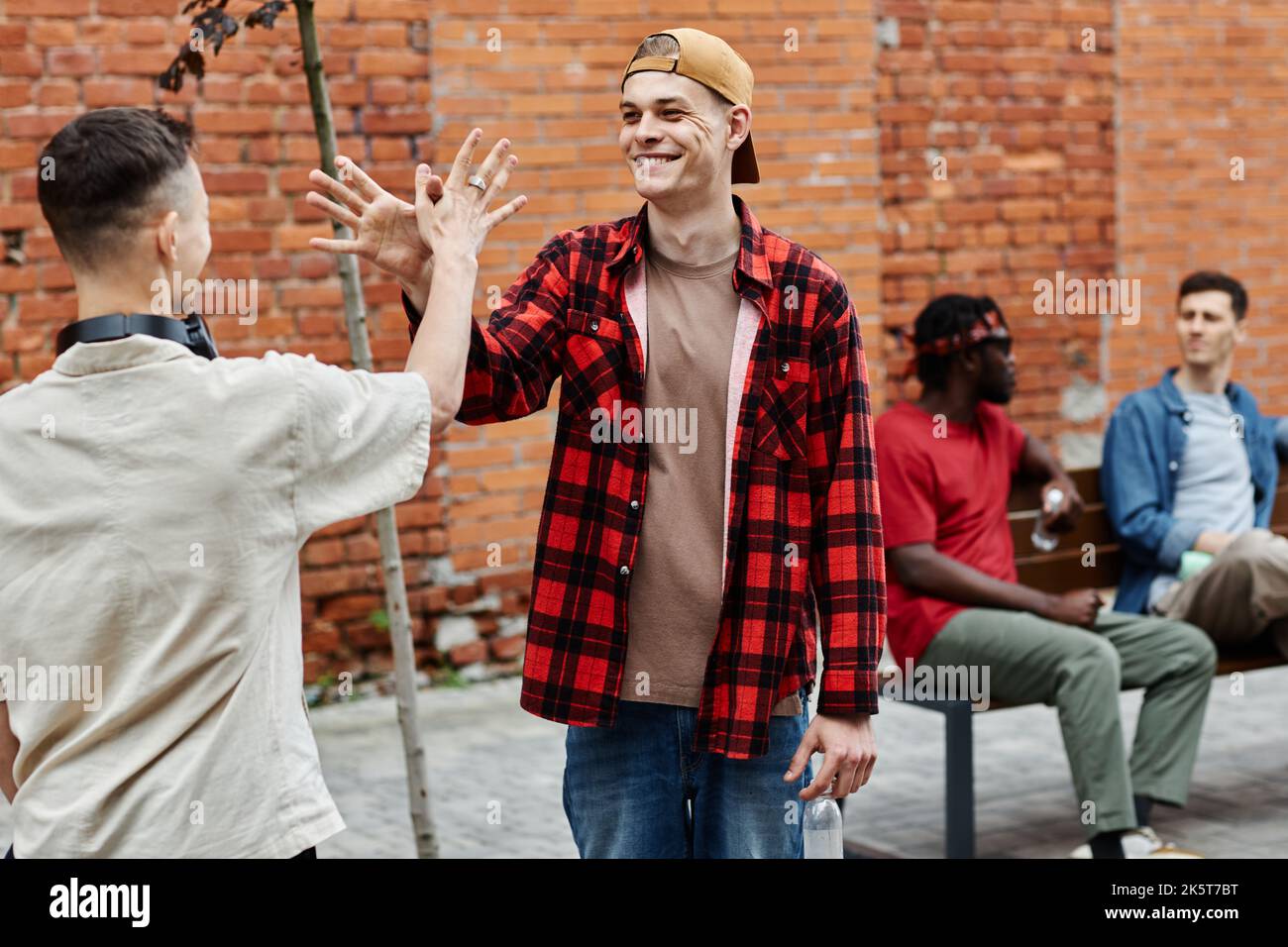 Waist up portrait of two young guys greeting each other with special ...