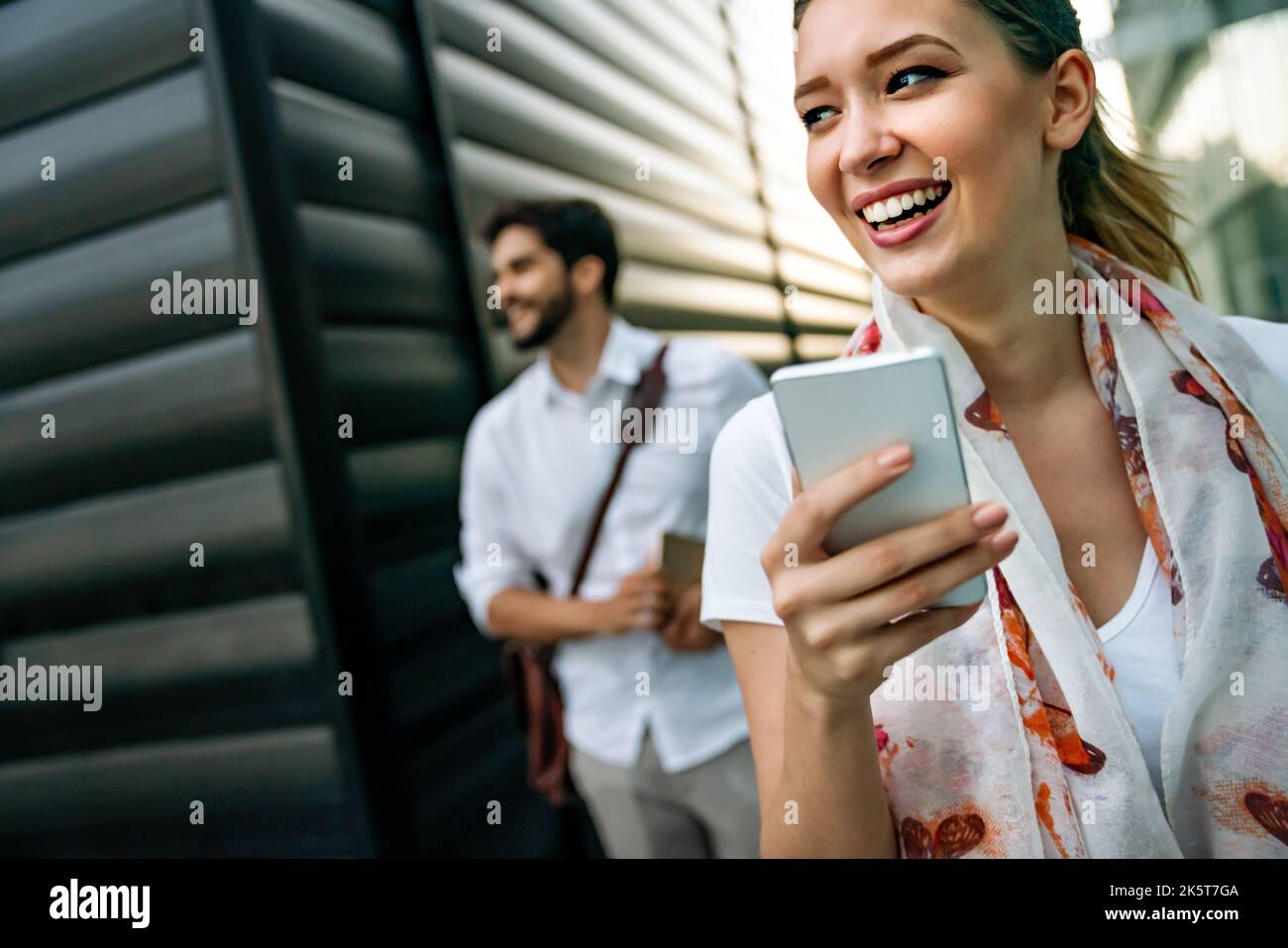 Happy businessman and woman with digital devices outdoors. Business ...