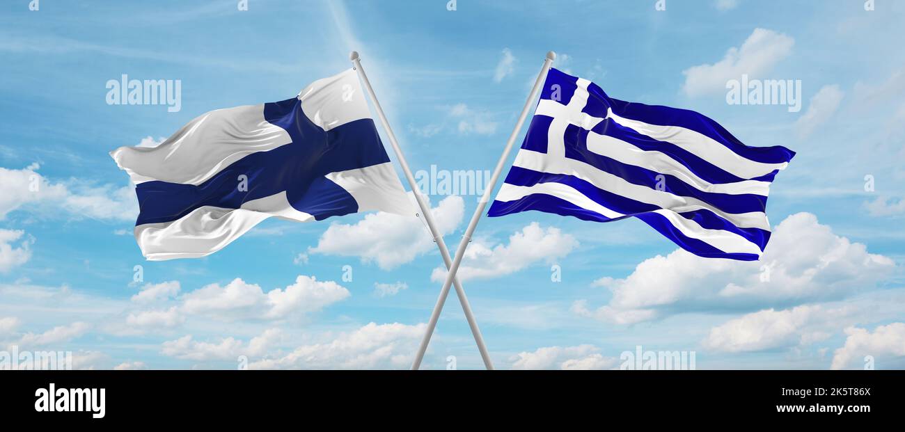two crossed flags Greece and finland waving in wind at cloudy sky ...