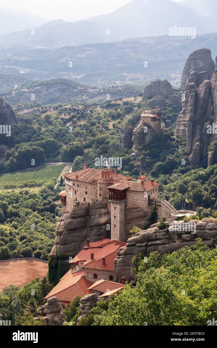 Vertical shot of Holy Monastery of Rousanou surrounded by other higher ...