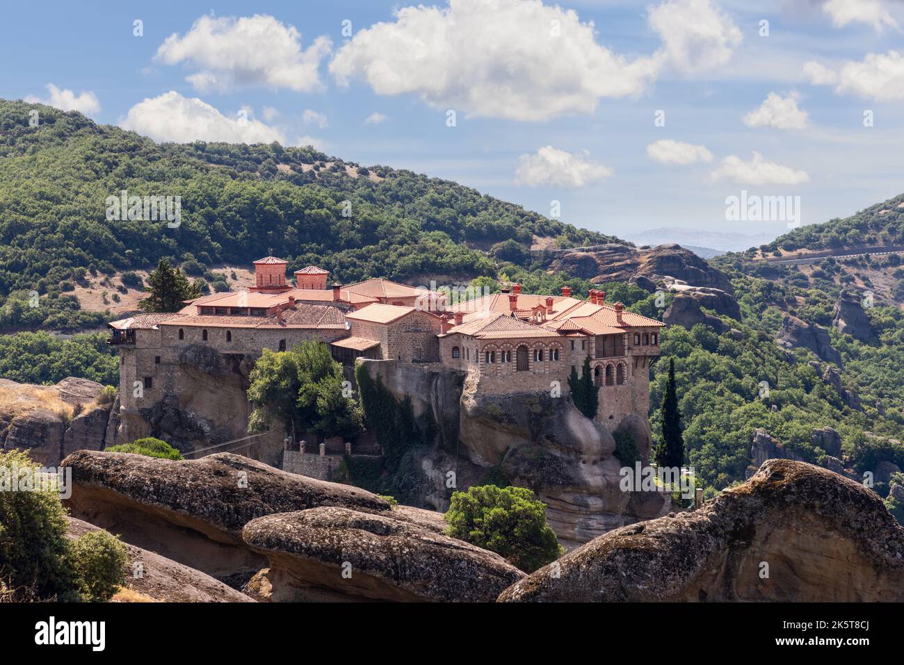 Red tiled roofs, chimneys and ornamented arched windows of religious ...