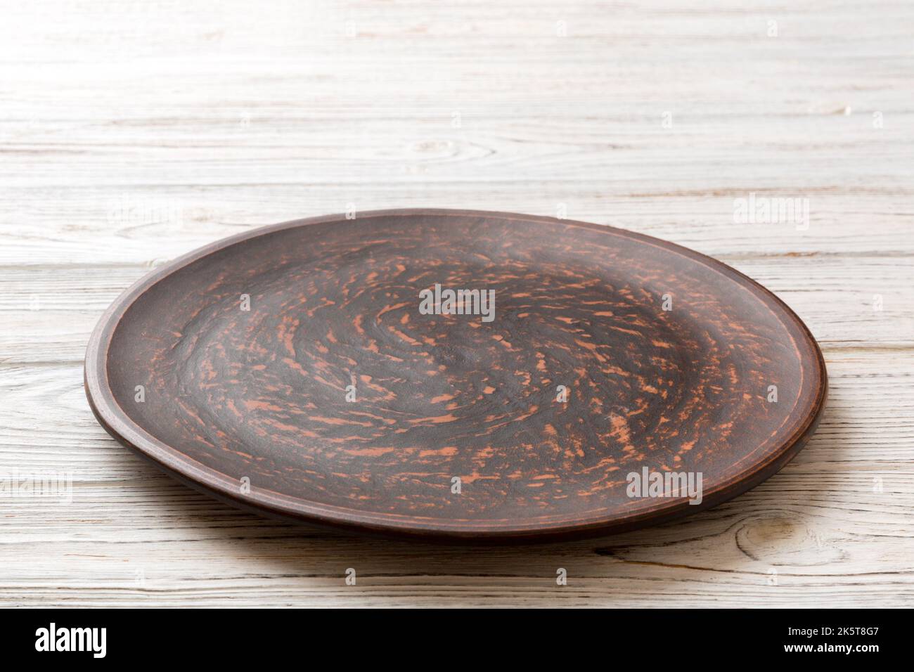 Perspective view of empty plate on wooden background. Empty space for ...