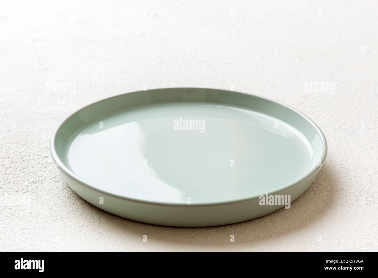 Perspective view of empty blue plate on cement background. Empty space ...