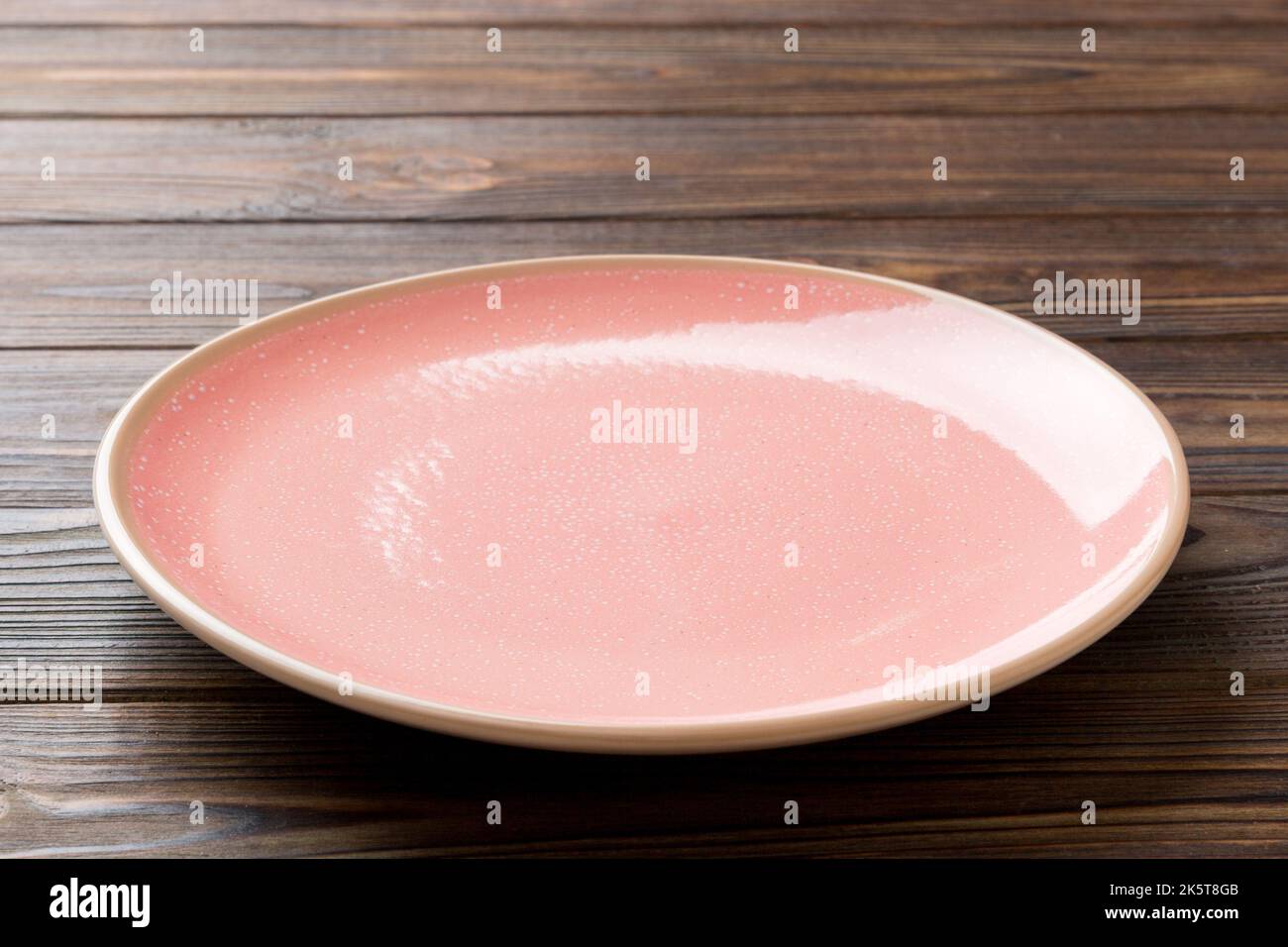 Perspective view of empty pink plate on wooden background. Empty space ...