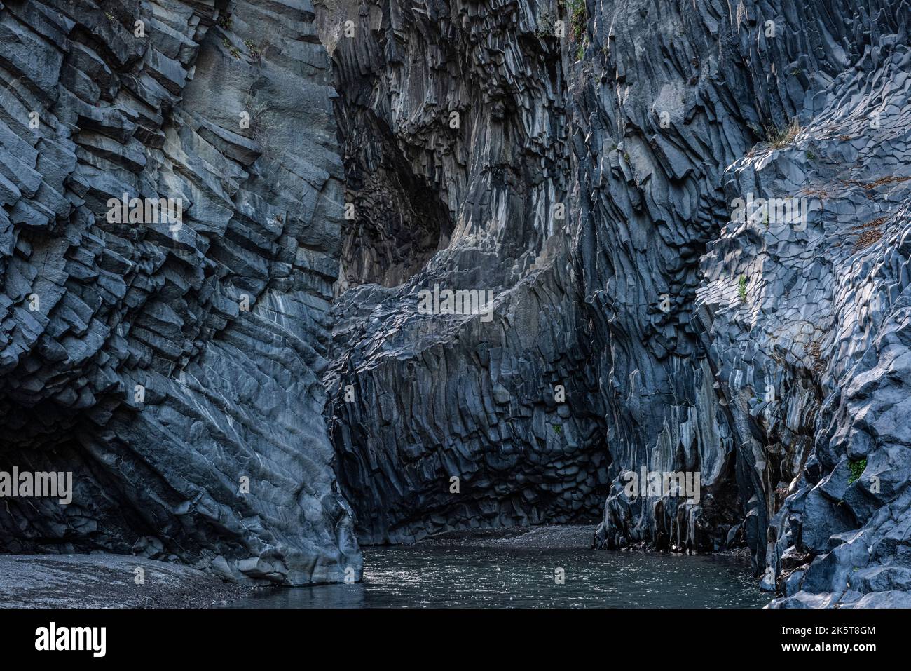 Dramatic volcanic basalt rock formations in the Gola dell'Alcantara, a ...