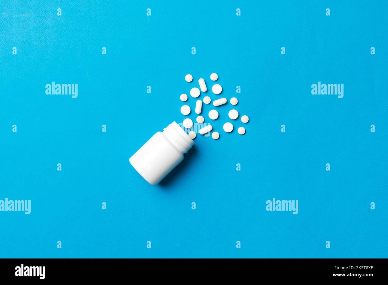 Multicolored pills and capsules in plastic bottle on Colored background ...