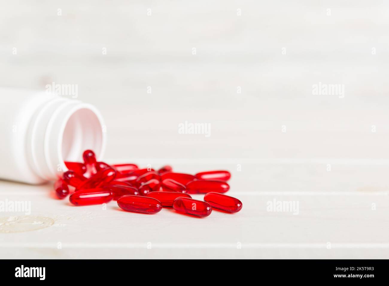 Red pills spilled around a pill bottle. Medicines and prescription ...