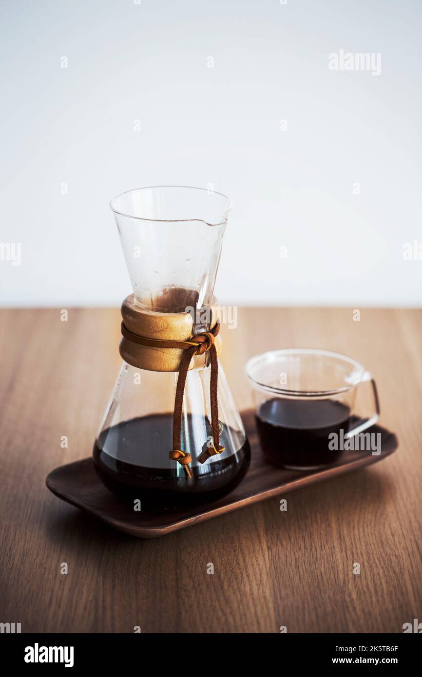 A vertical shot of drip coffee pot and cup of coffee on a tray on ...