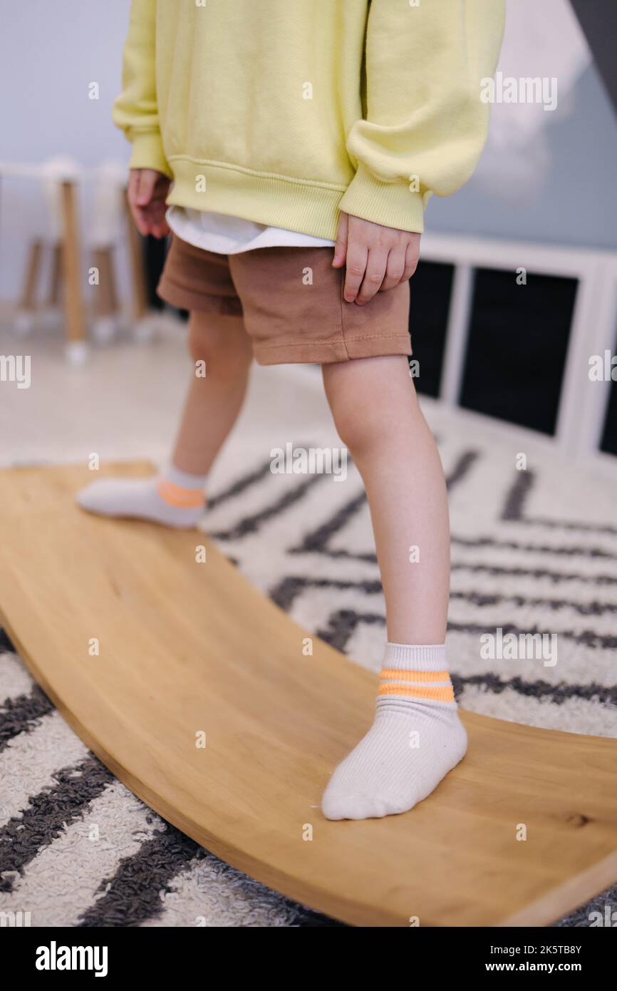 Boy balancing on a board, trainig of the vestibular apparatus. Close-up ...
