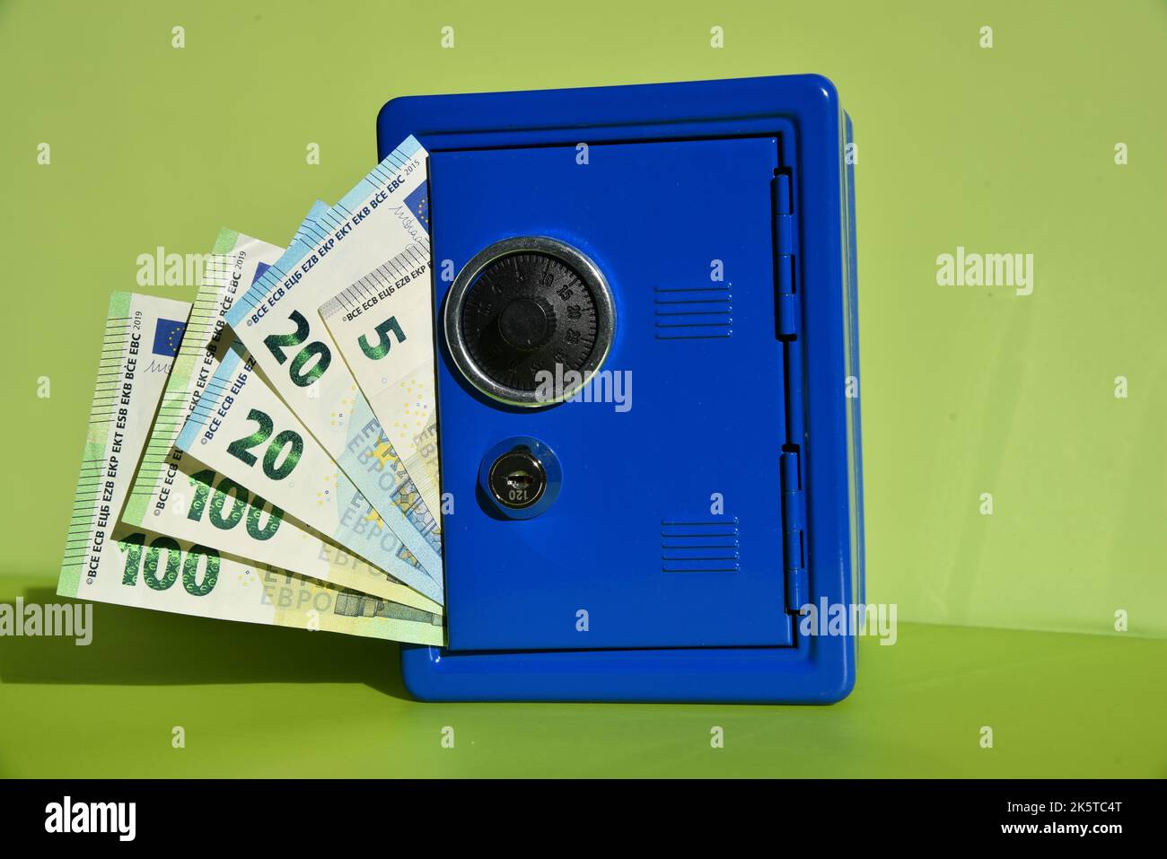 a small blue toy safe with euro bills Stock Photo - Alamy