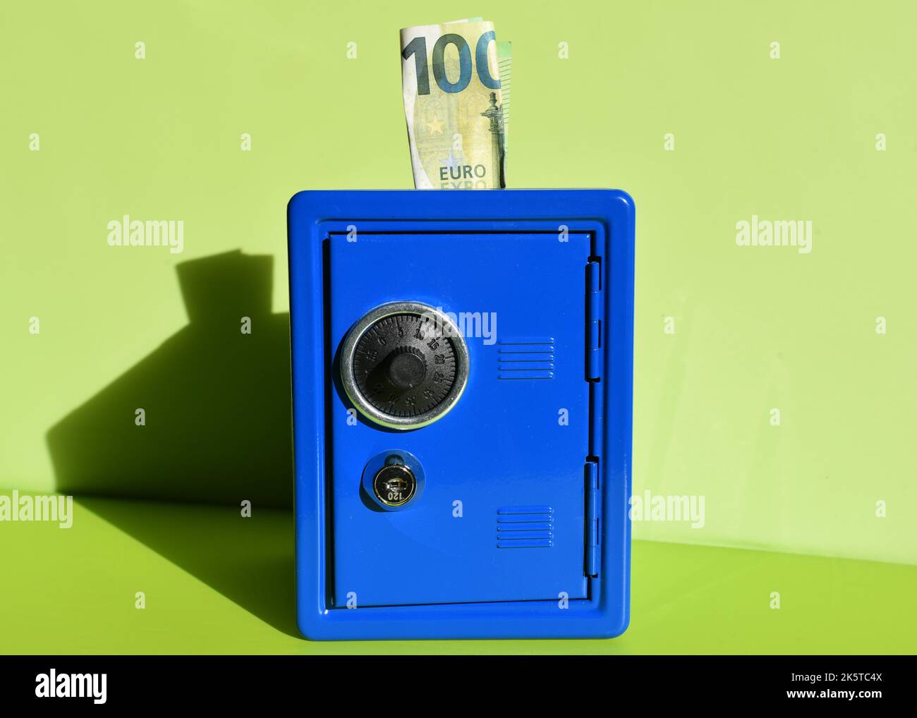a small blue toy safe with euro bills Stock Photo - Alamy