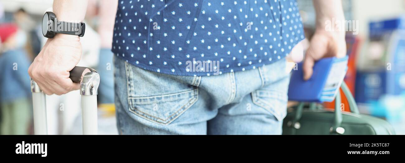 A young man with suitcase and passport in his hands, rear view Stock ...
