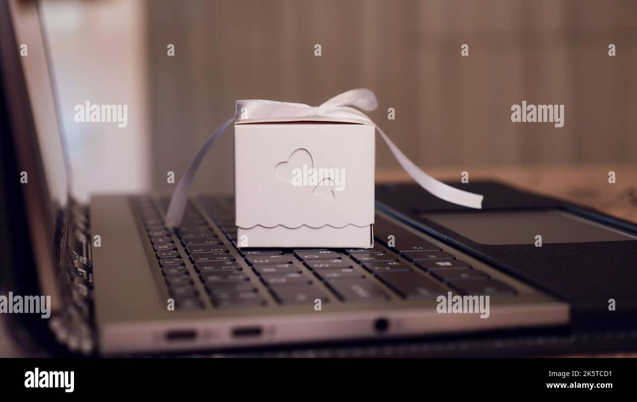 Gifts wrapping close-up. small box on a laptop. gift box with a bow ...