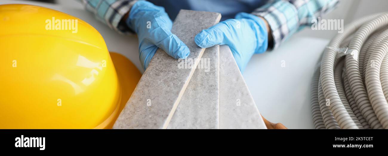 Hands in gloves hold samples of stone tiles, close-up Stock Photo - Alamy