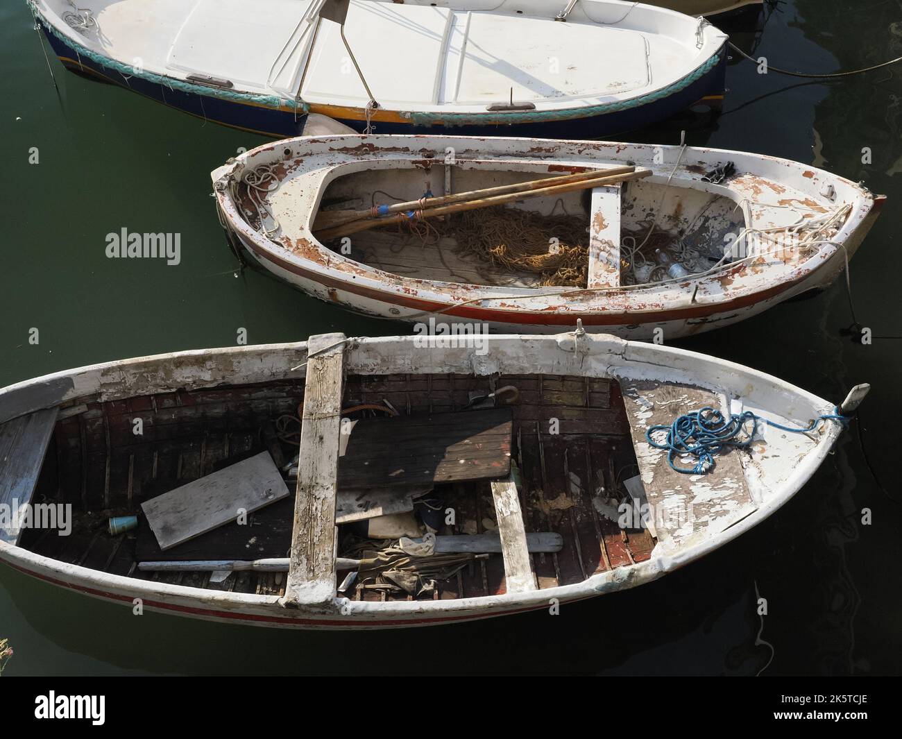 old abandoned small wooden fishing boat in sea waters of the harbor ...