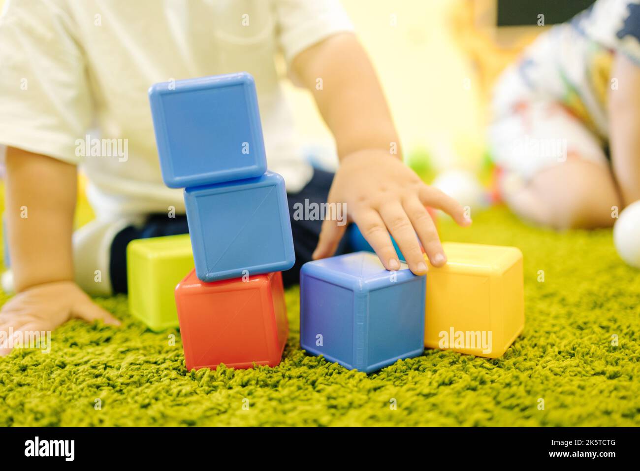 Little boy builds a tower of cubes. Kindergarten Stock Photo - Alamy