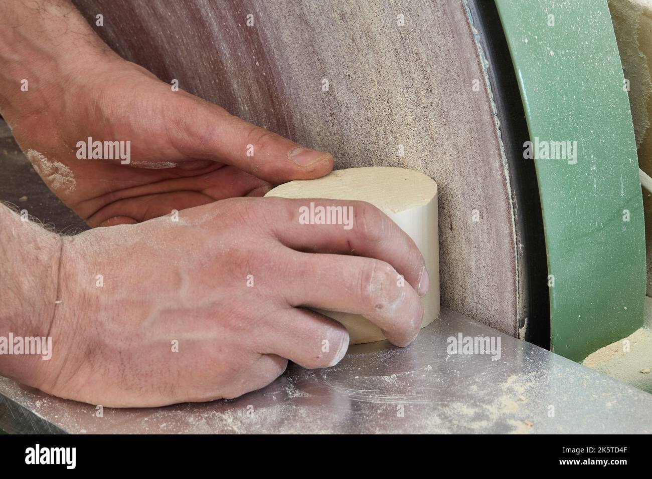 A closeup of traditional wood artist at work smoothing the timber Stock ...