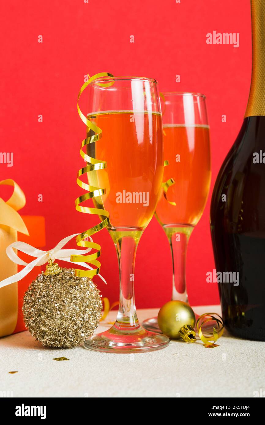 Champagne bottle with confetti, glasses and christmas decor on colored ...