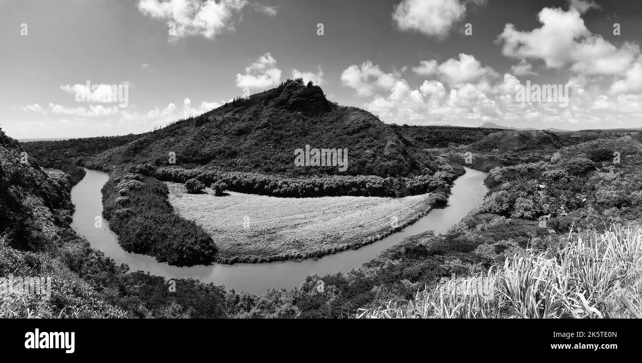 A landscape shot of the Kauai's Wailua river surrounded by grass and ...