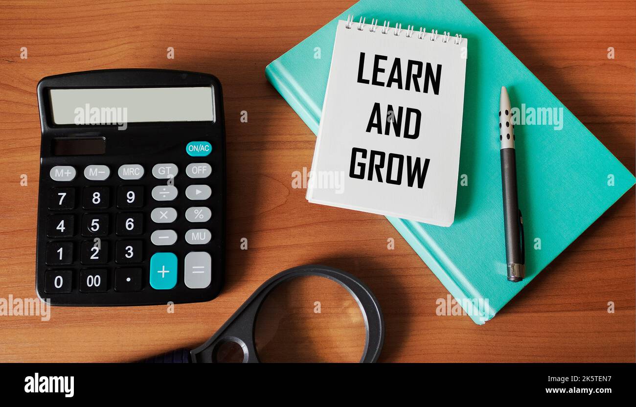 Learn and grow text in notepad on wooden background with calculator ...