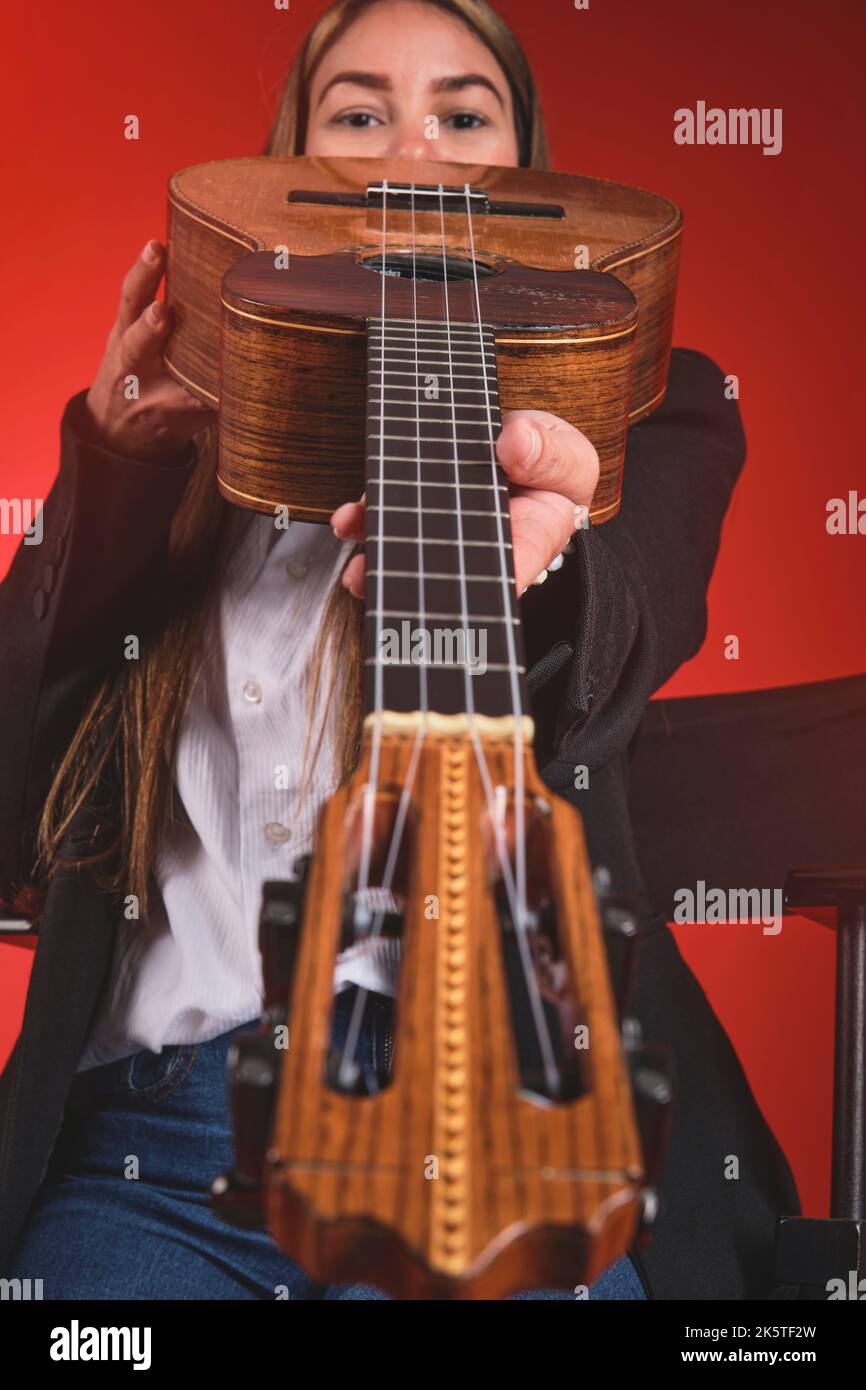Beautiful young woman playing a CUATRO, typical Venezuelan instrument ...