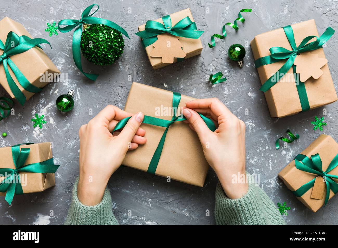 Woman is packing surprise gift for Christmas holidays, sitting at ...