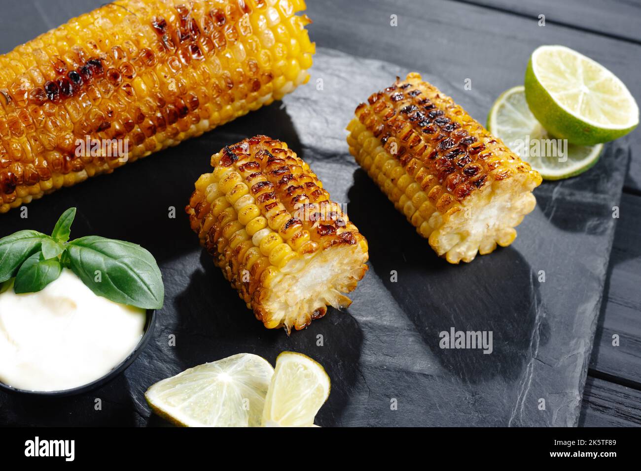 Grilled corn on the cob with butter and salt on the grill plate, close ...